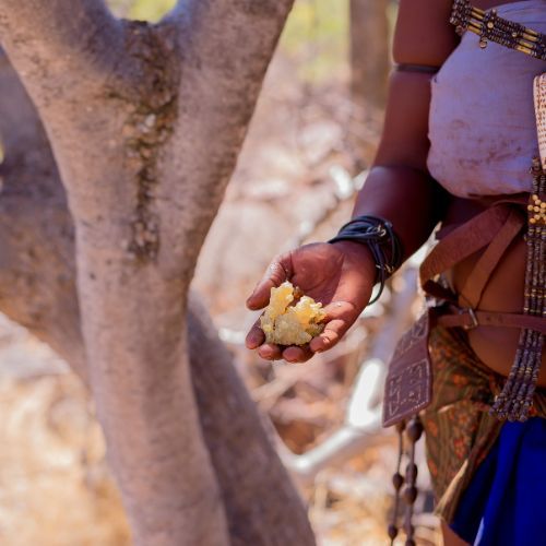 Himba woman holding Omumbiri resin